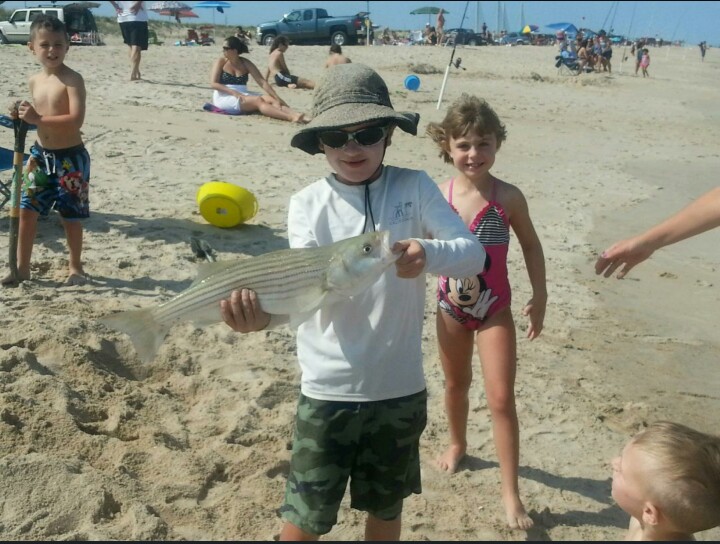 Jeremy Roop's son with a short striped bass form the surf at 3Rs ...